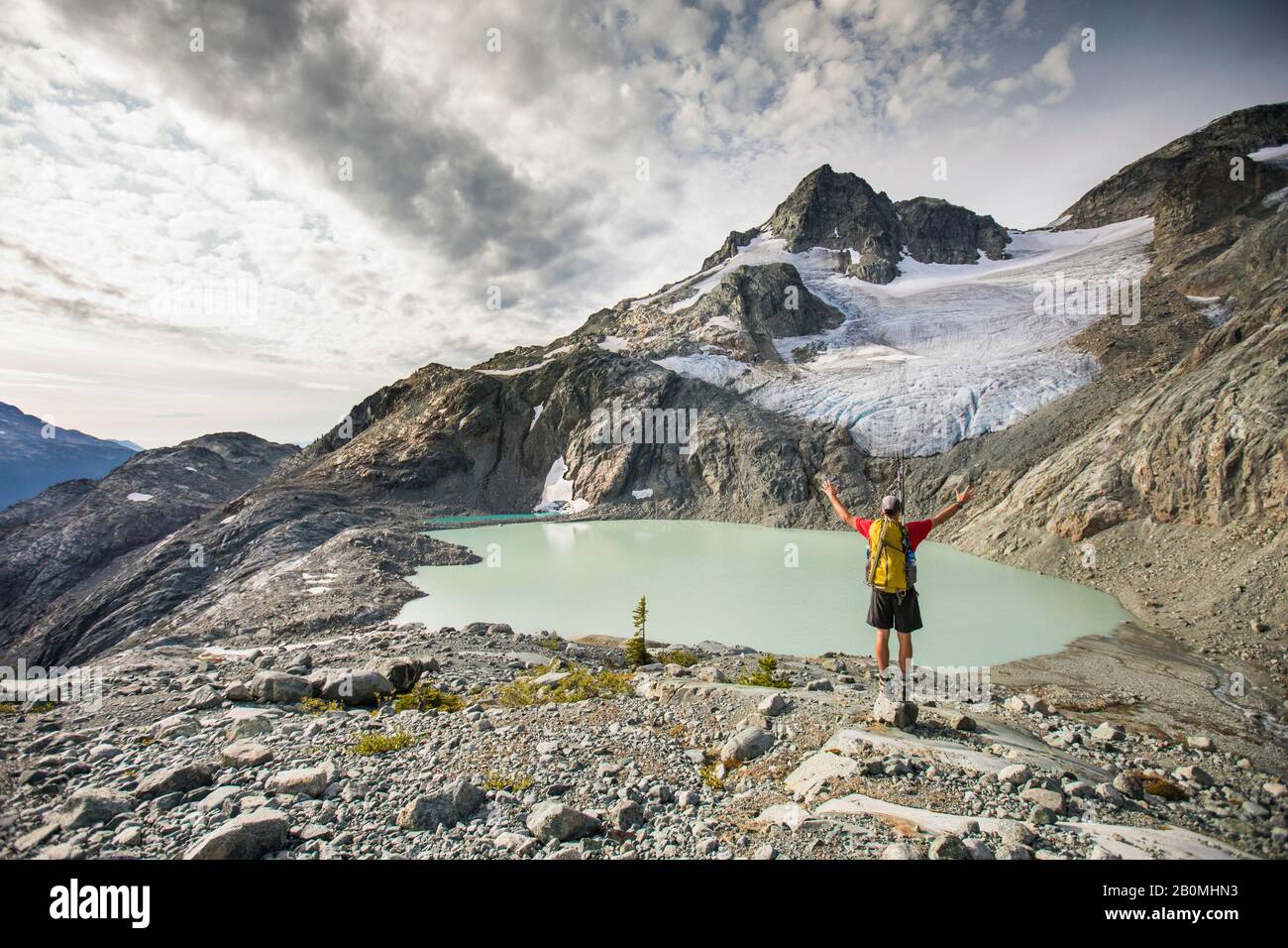 Rear view of backpacker looking at beautiful mountain view Stock Photo ...