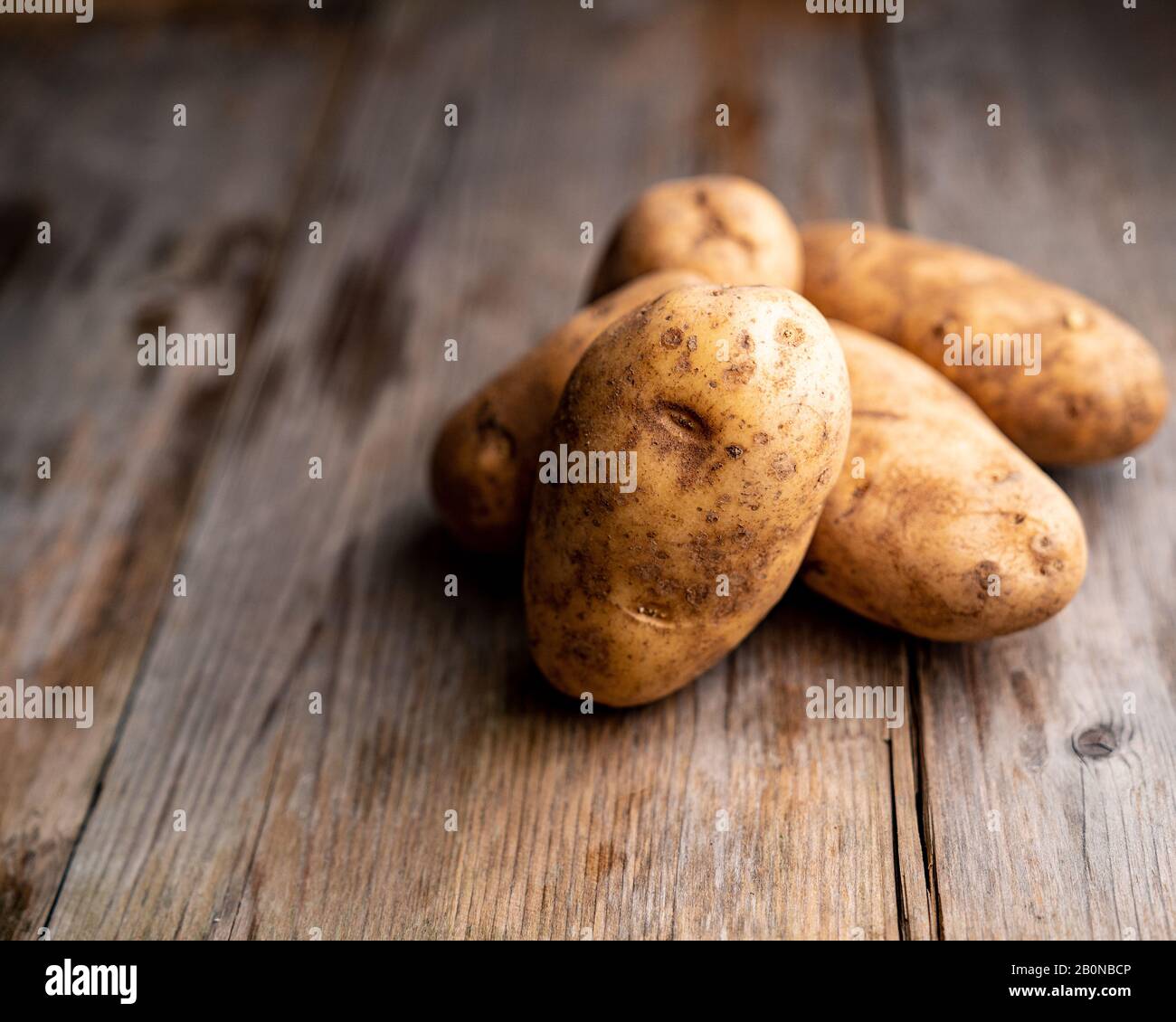 Potatoes on a rustic wood surface Stock Photo - Alamy