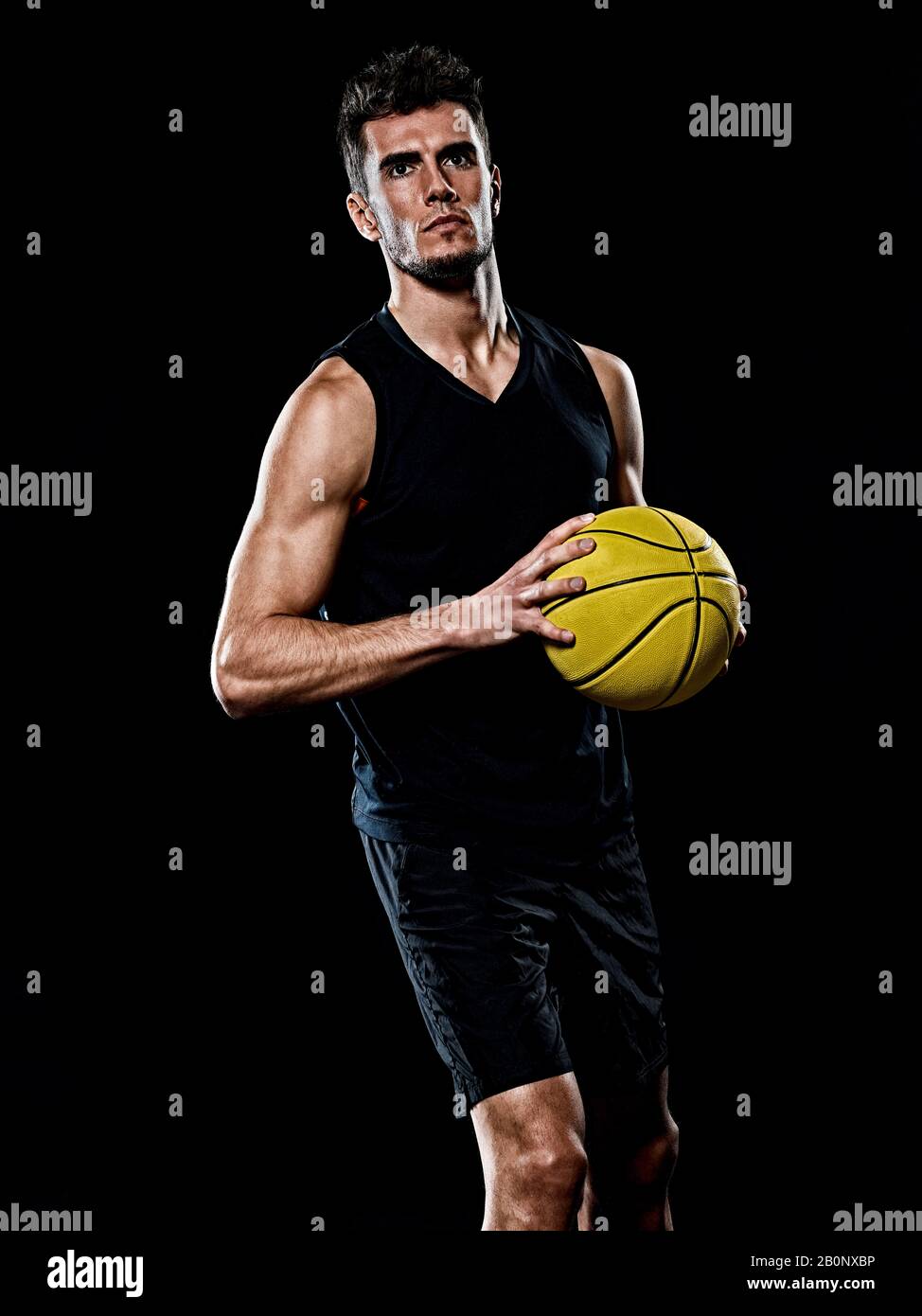 one caucasian young basketball player man in studio isolated on black ...