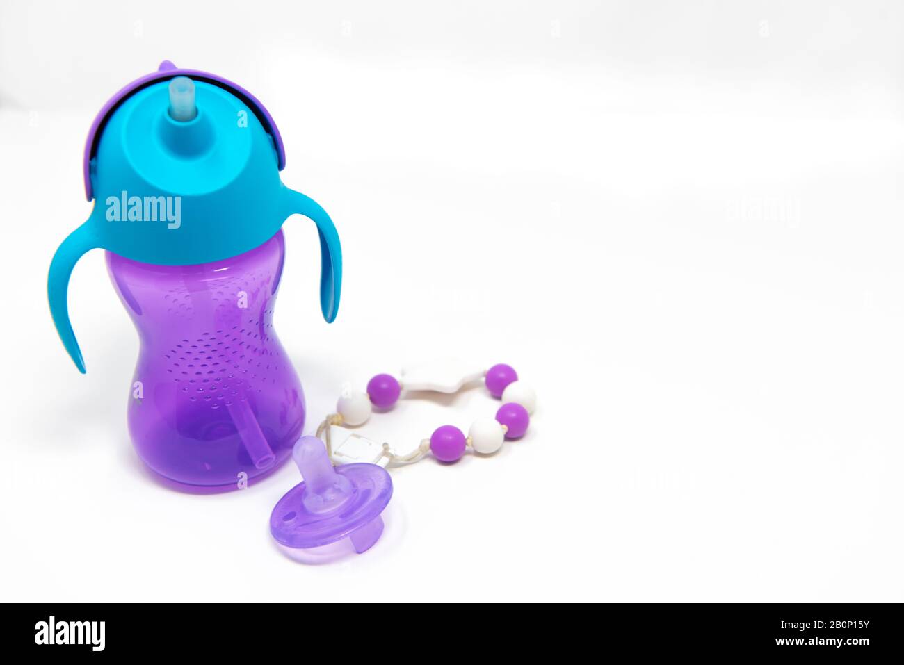 Purple plastic sippy cup and pacifier on white background Stock Photo ...