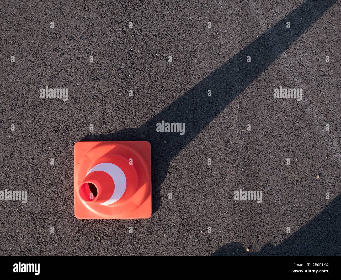 Traffic cone with shadow on asphalt. Traffic cone, with white and ...