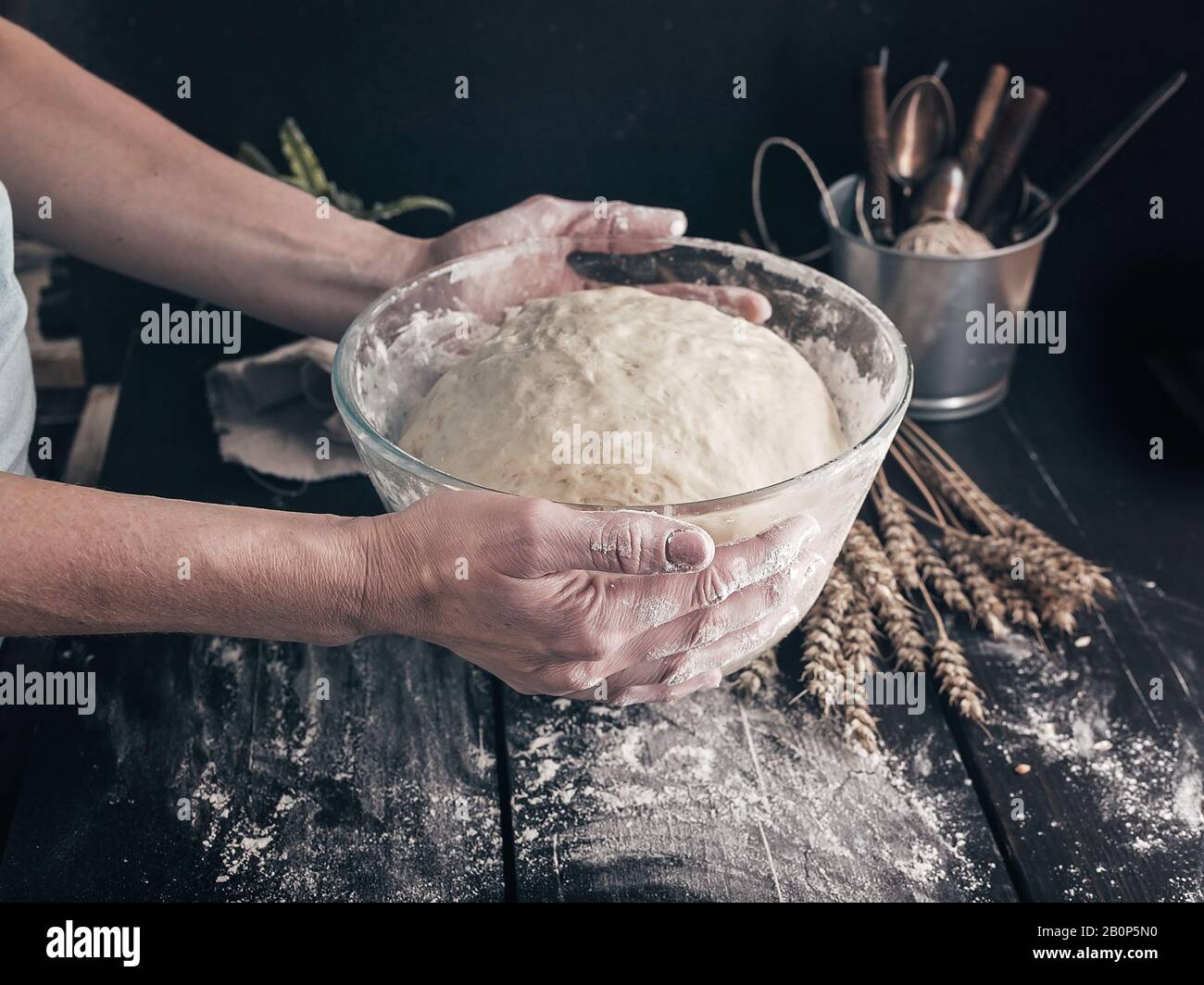 Female hands hold fermented homemade pastry for buns. Close-up. Step by ...