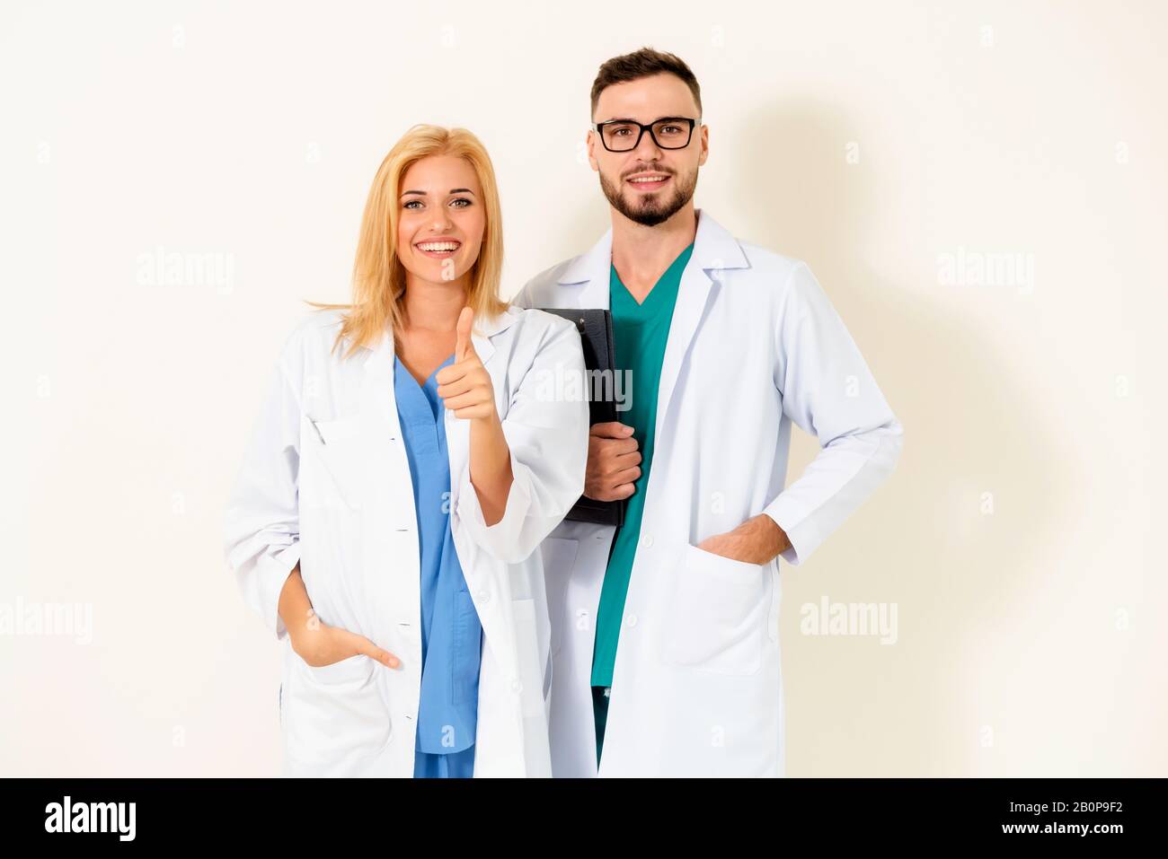 Portrait of confident GP doctor and surgical doctor on white background ...