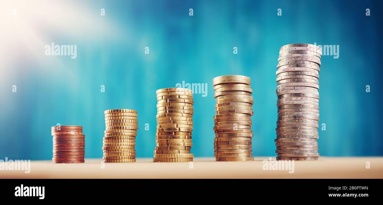 stacked coins on blue background. Money columns Stock Photo - Alamy