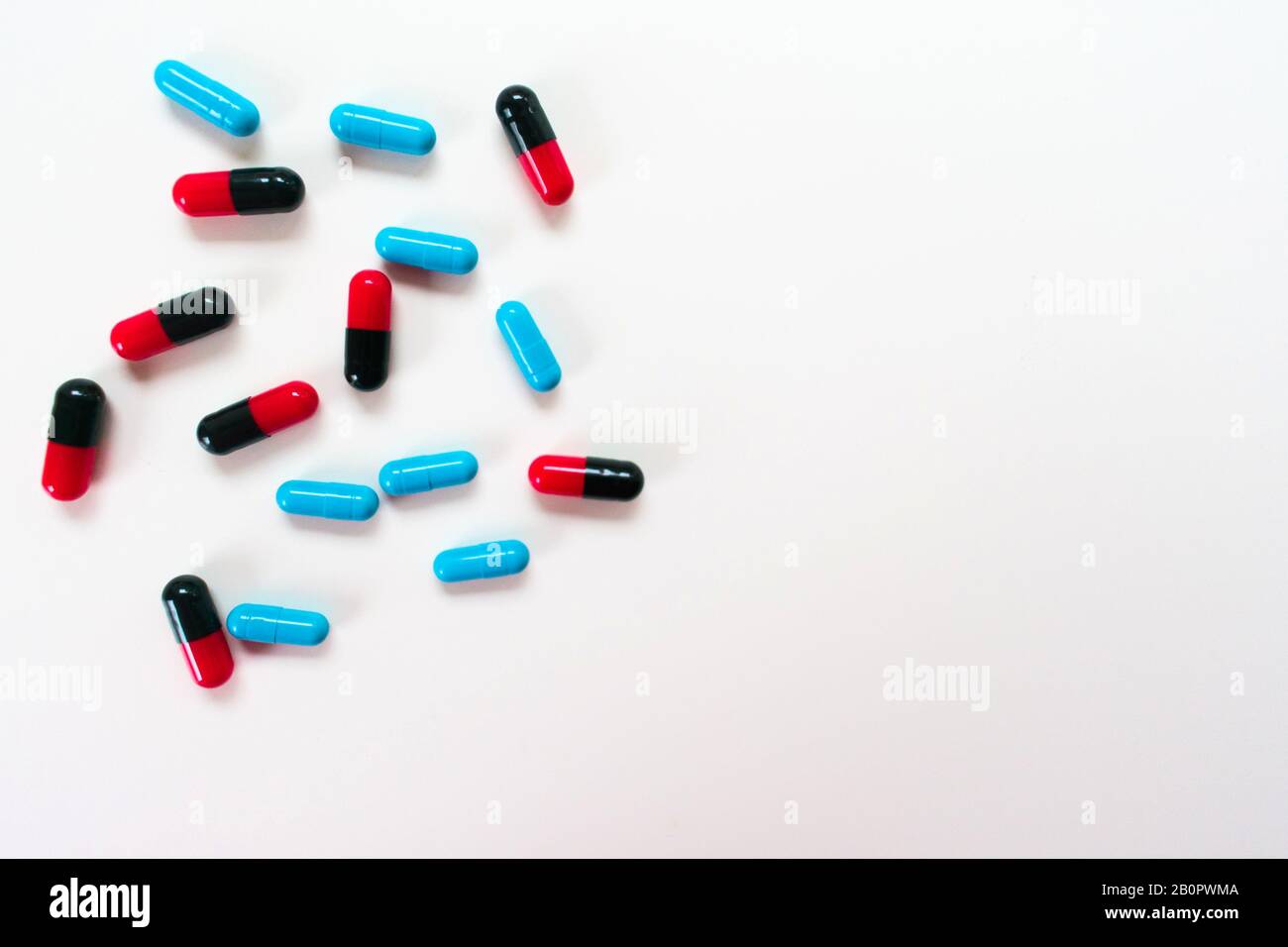 Capsules of red, blue and black color on a white background. Copy space ...