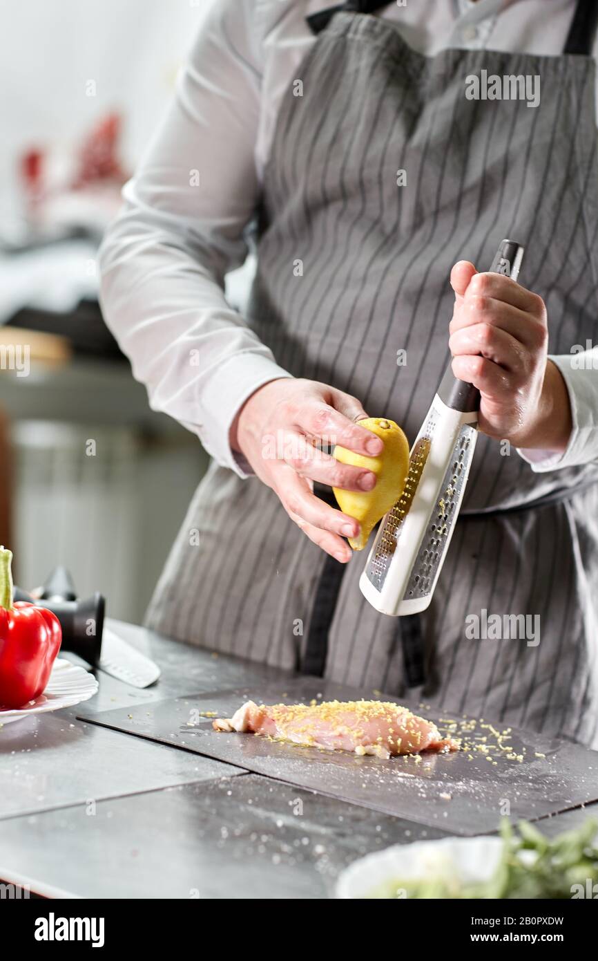 Chief chops and marinates chicken. Professional chef in a kitchen of ...