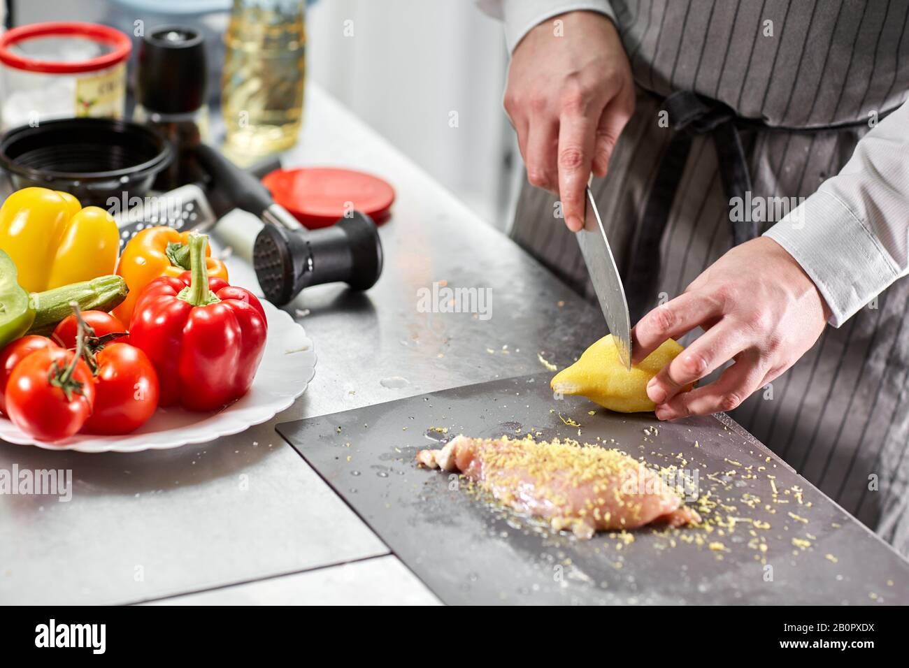 Chief chops and marinates chicken. Professional chef in a kitchen of ...