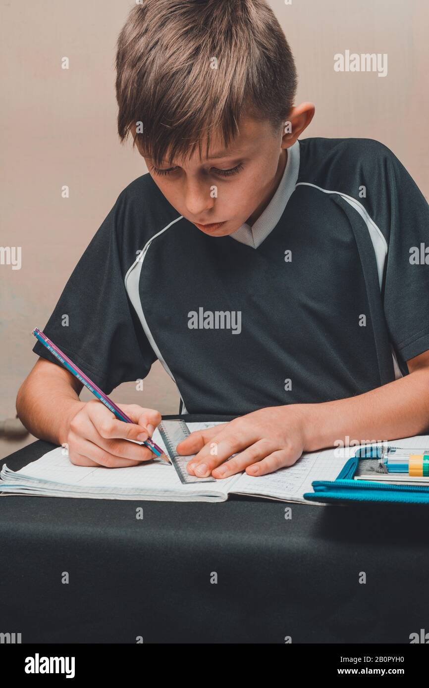 Little schoolboy bored homework in a school notebook for drawing Stock ...
