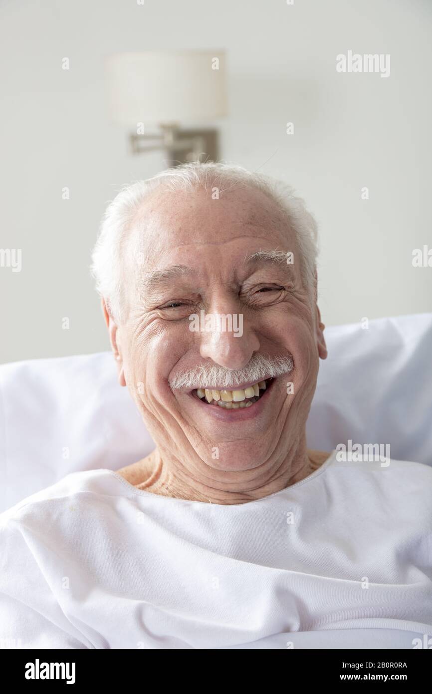 Happy elderly patient smiling in hospital bed. Health and happiness ...