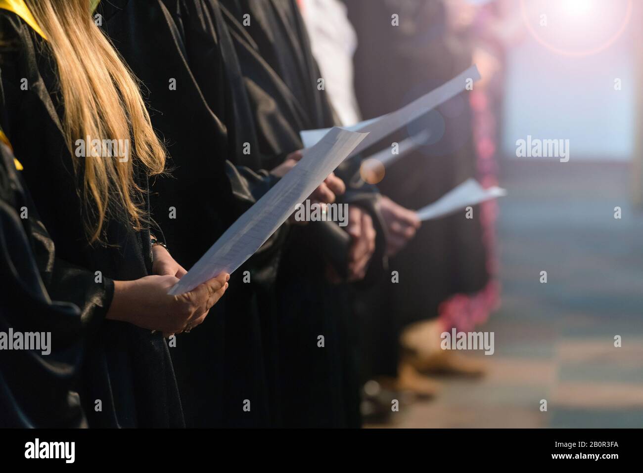 Choir singers holding musical score and singing on student graduation ...