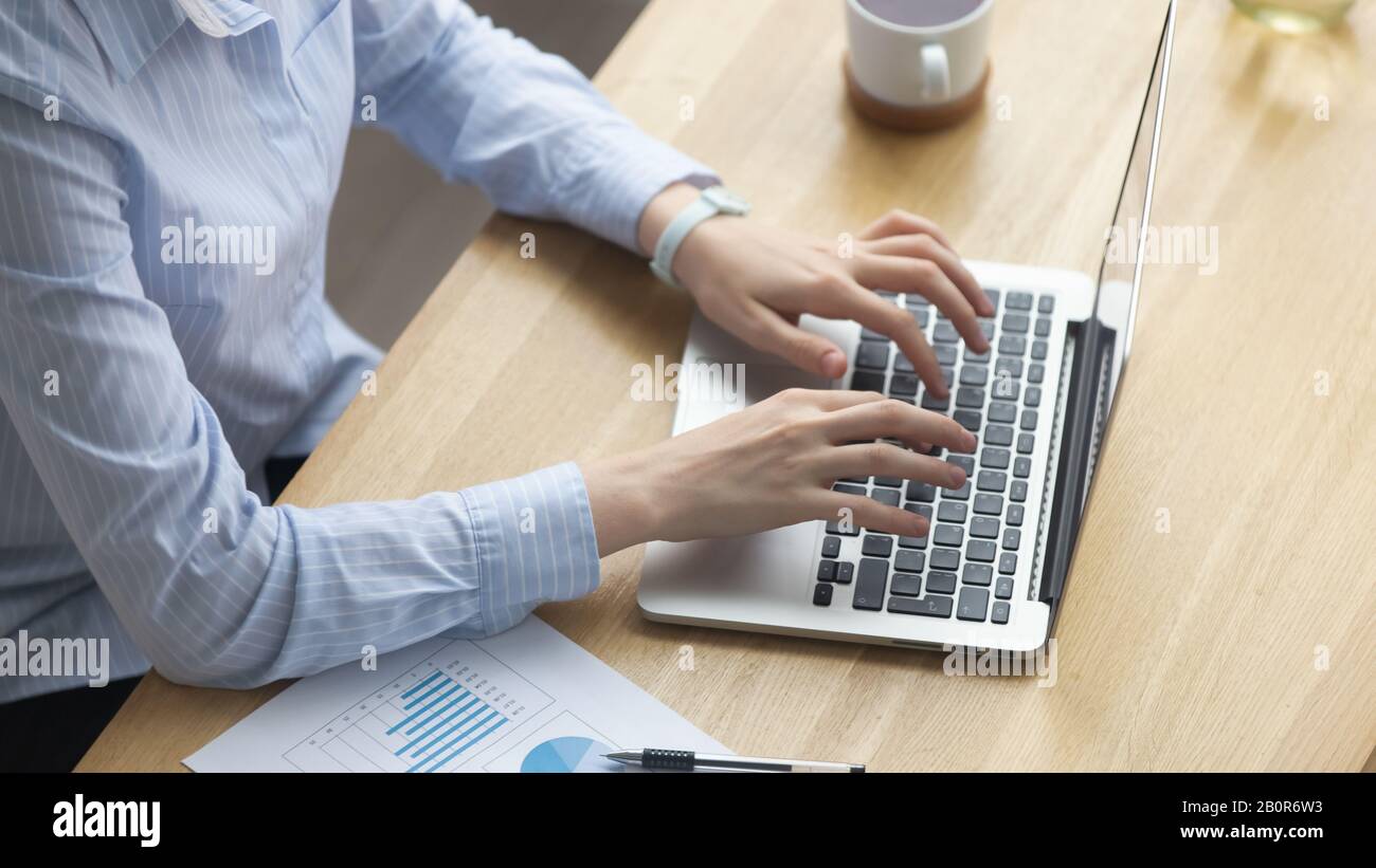 Close up businesswoman using laptop, writing financial report ...