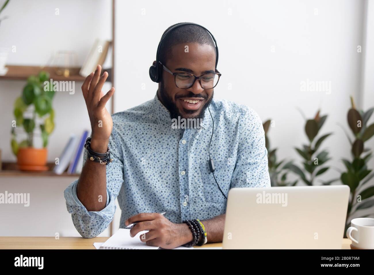 Smiling African American Employee In Headphones Using Laptop Looking