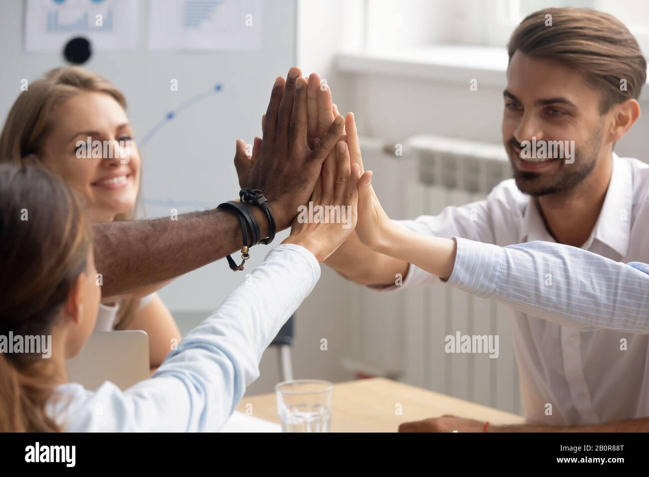 Close up diverse colleagues, employees team giving high five, celebrate ...