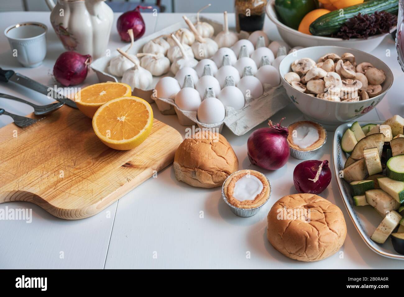 Food ingredients with fruits, vegetables,bread and kitchenware on table ...
