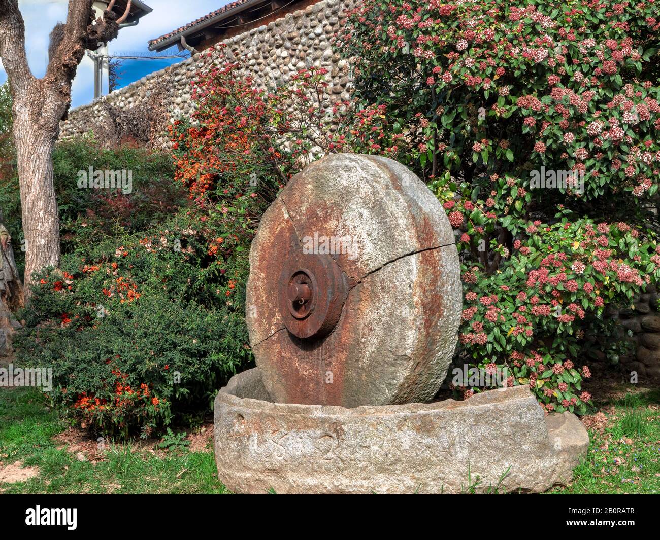 vintage stone tool of round shape called millstone used to grind ...