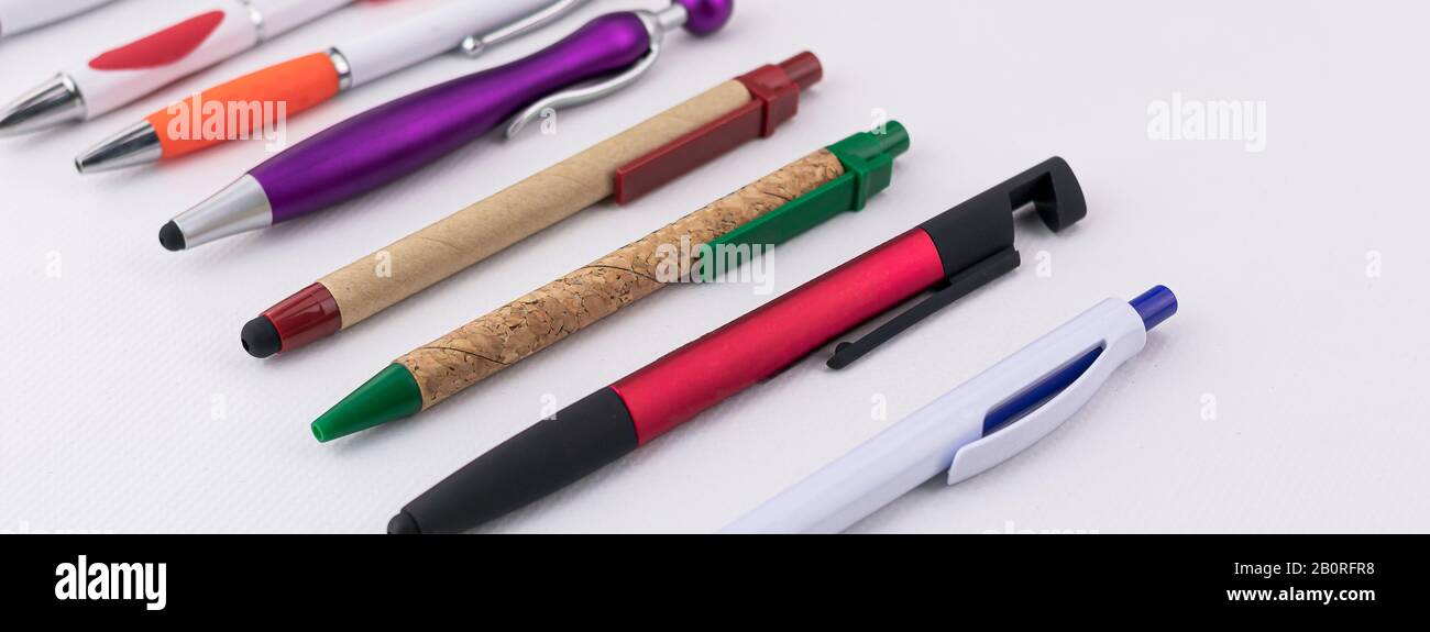 Pens aligned with different manufacturing designs and varied colors ...