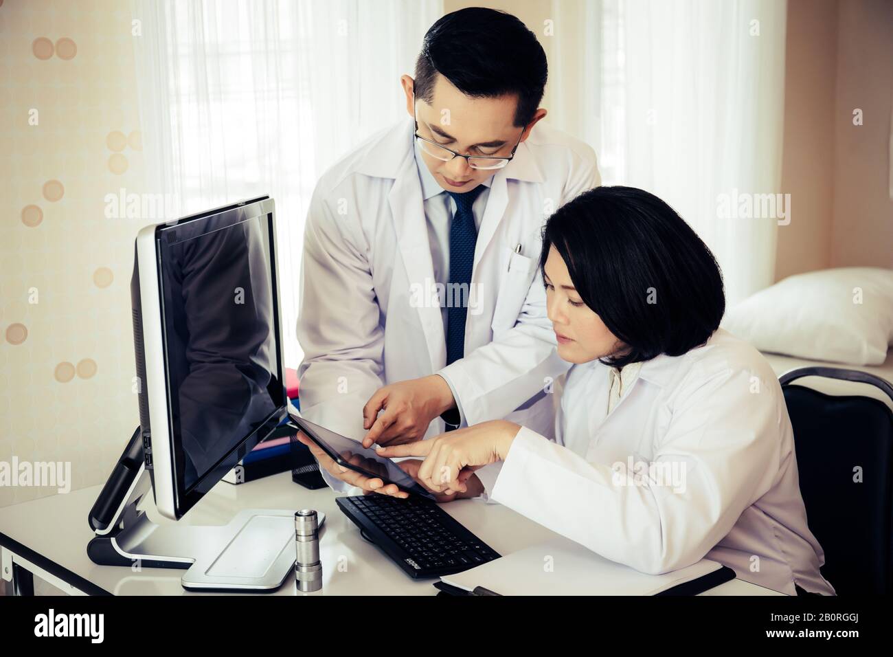Two Doctors discussing about patient report in ward at hospital Stock ...