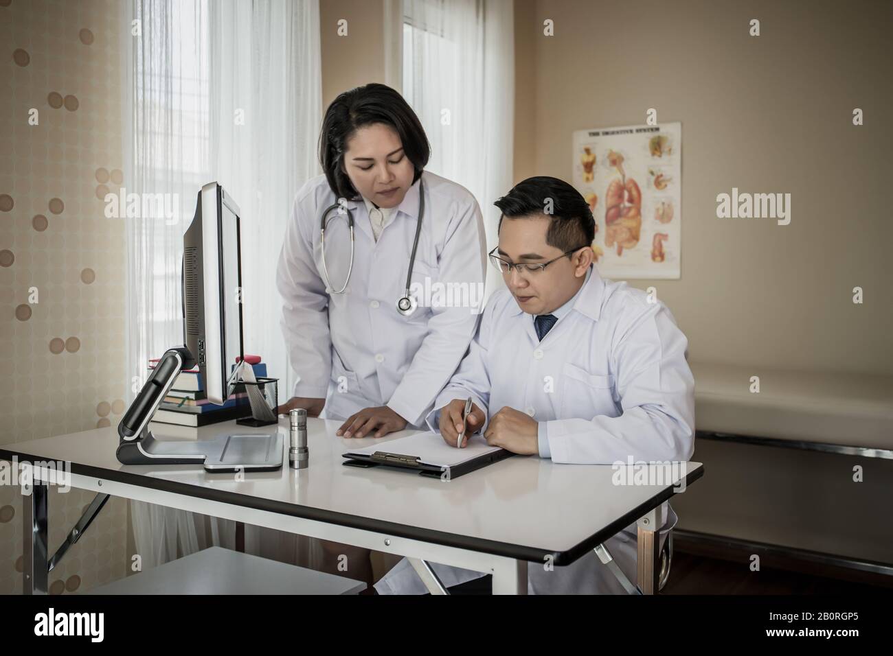 Group of doctors looking at computer on meeting at hospital ward Stock ...