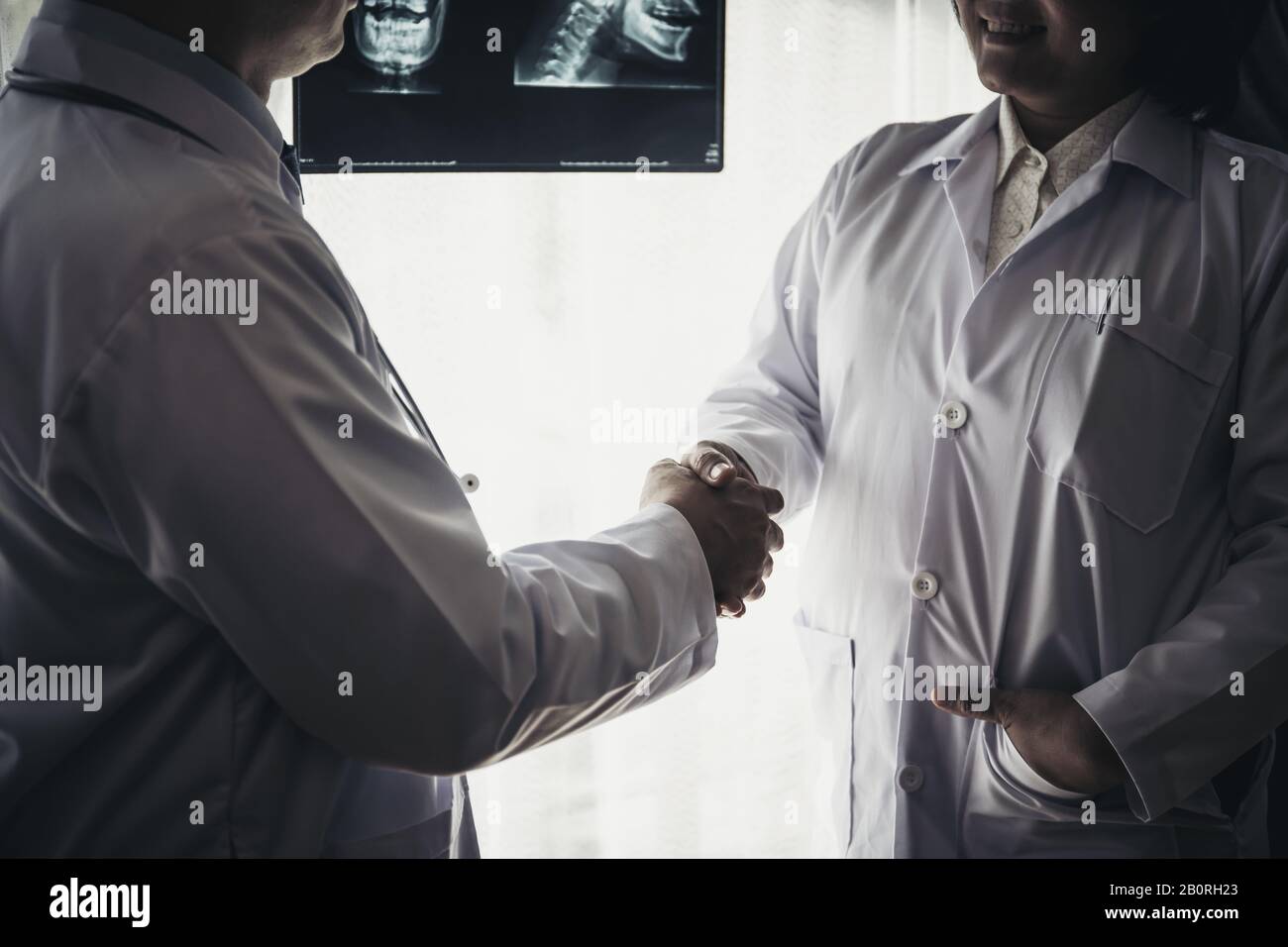 Close up of doctor giving a handshake to his partner, successfully ...