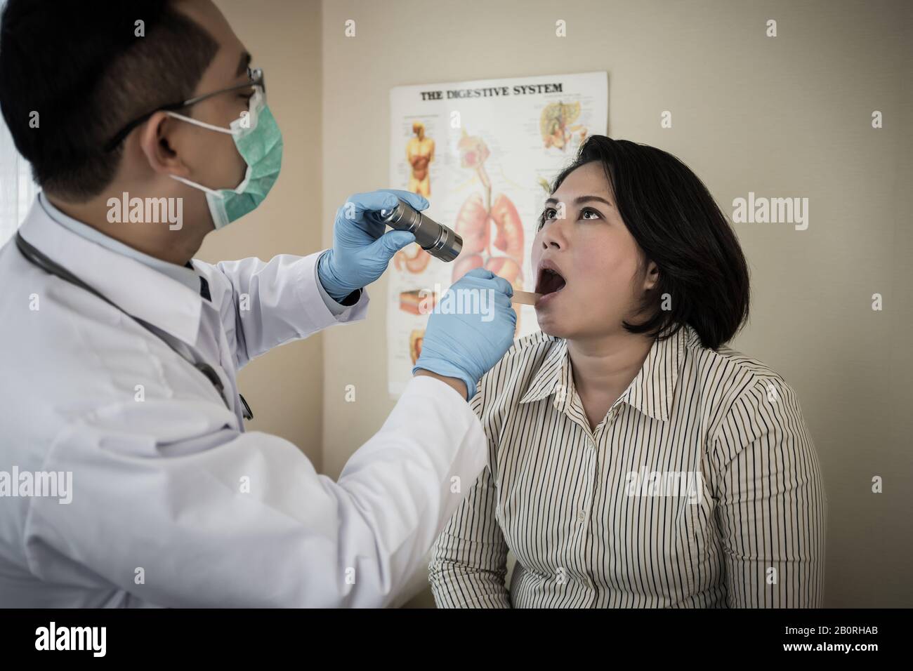 doctor in white uniform gown checkup patient's mouth with flashlight ...