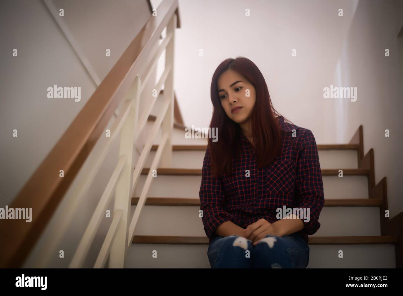 Displeased sad young woman sitting on stairs Stock Photo - Alamy