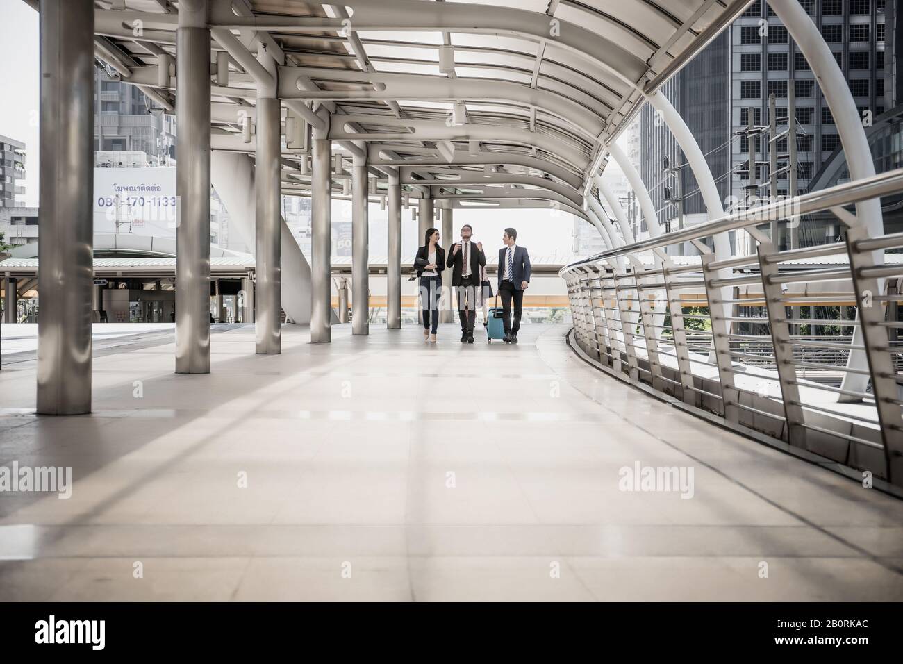 Team of business colleagues meeting while walking in a modern city to ...