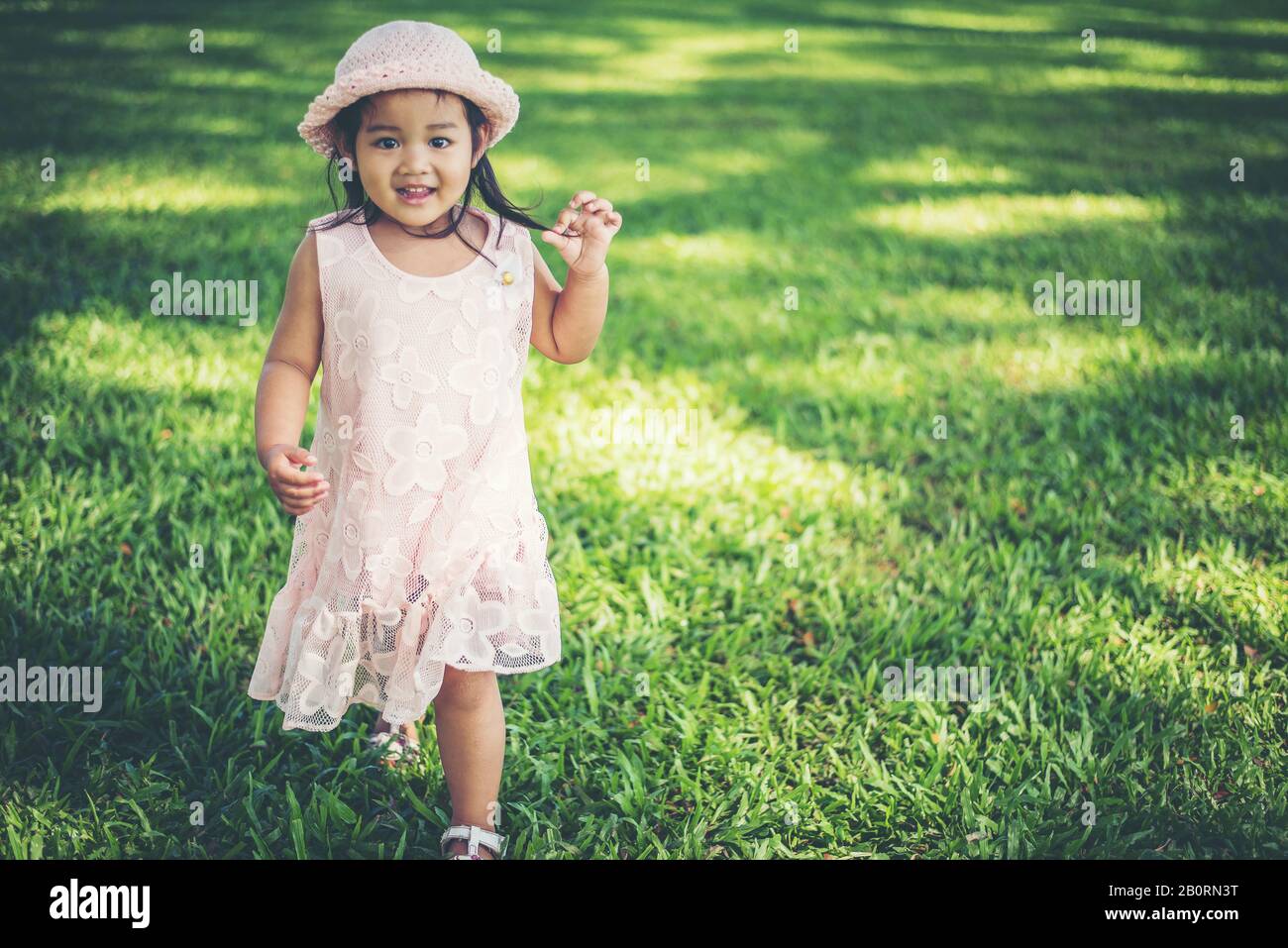 Little girl walking alone in a park or forest Stock Photo - Alamy
