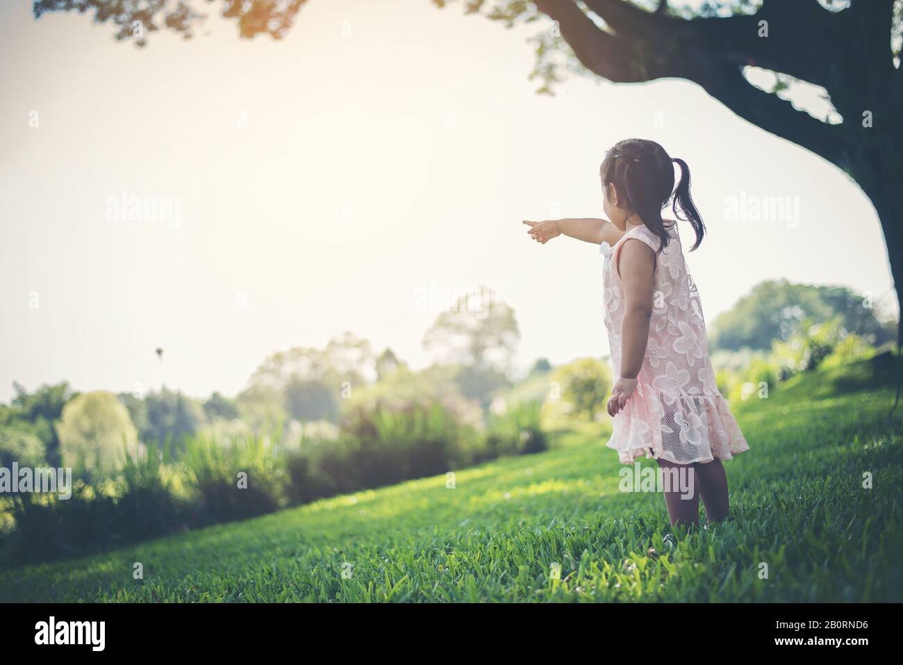 Little girl point with a finger to something in the park Stock Photo ...