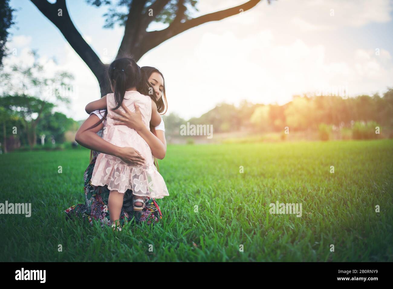 Happy family Mother hugging daughter and playing in the park Stock Photo - Alamy