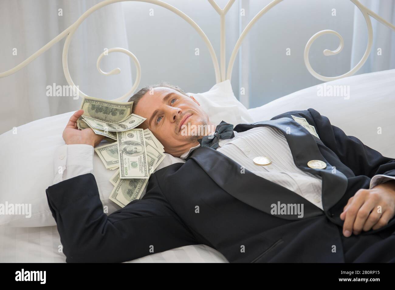Rich man lying on the bed with dollar banknotes. Success business ...