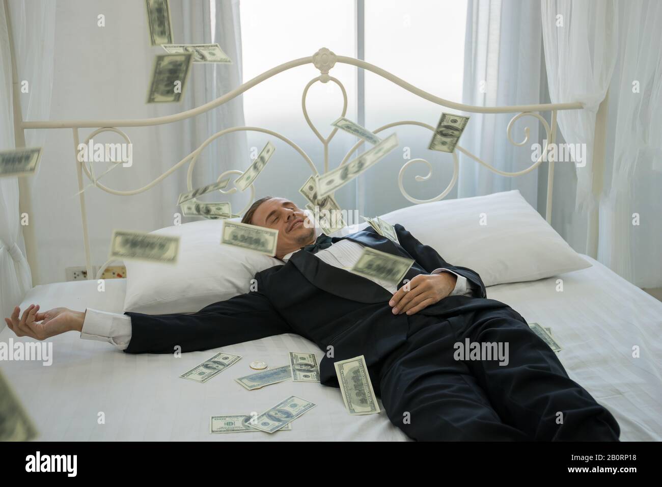 Rich man lying on the bed with dollar banknotes. Success business ...