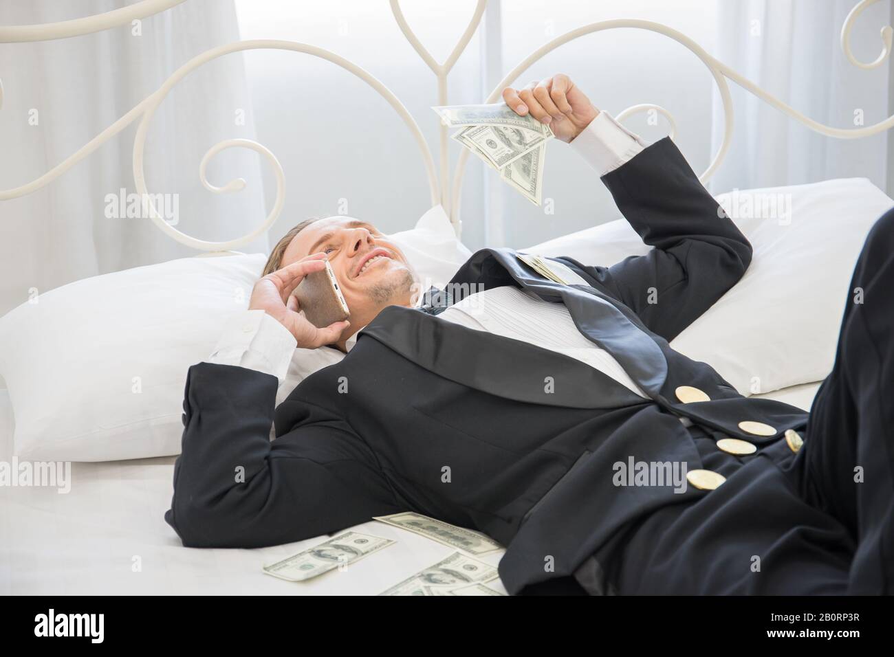 Rich man lying on the bed with dollar banknotes. Success business ...