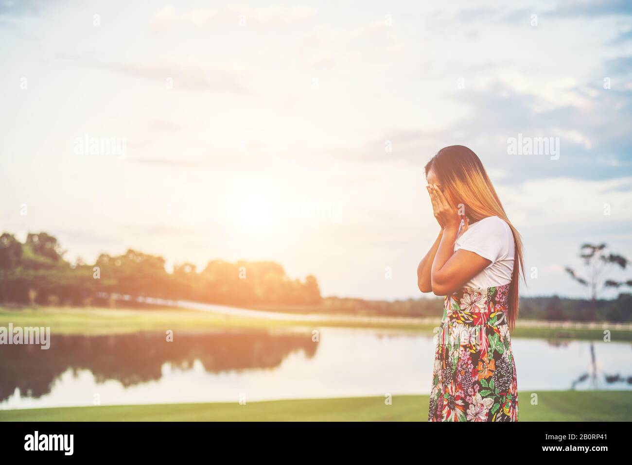 Sad woman standing crying beside the lake Stock Photo - Alamy