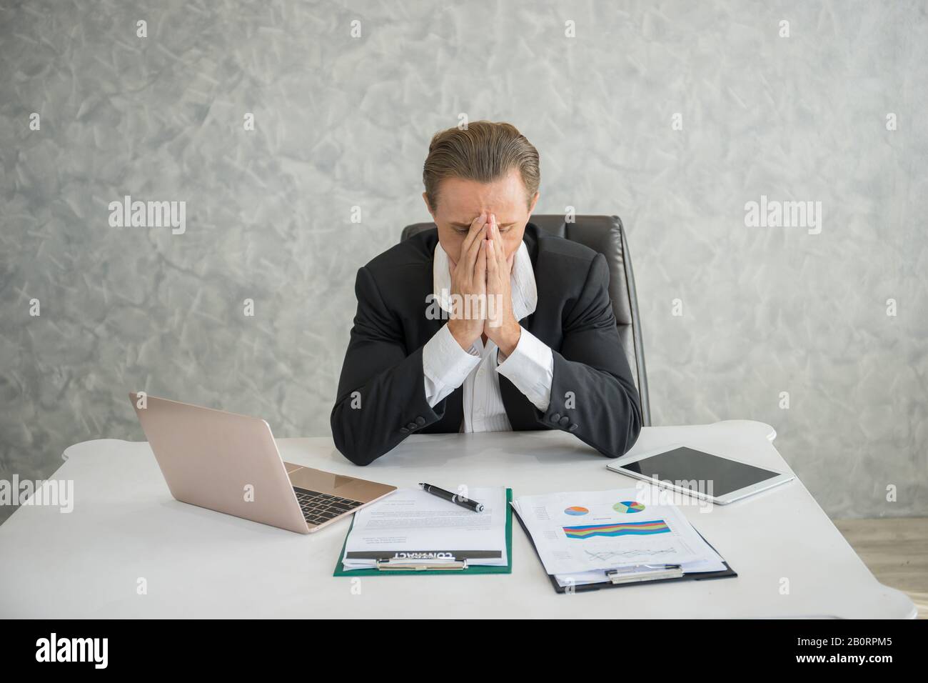 Serious businessman stressed out at work in office. fail business ...