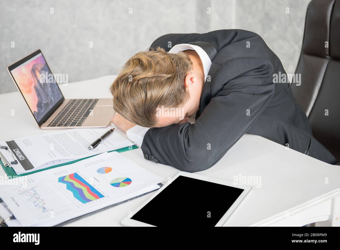 Tired businessman sleeping at workplace after hard work and work all ...
