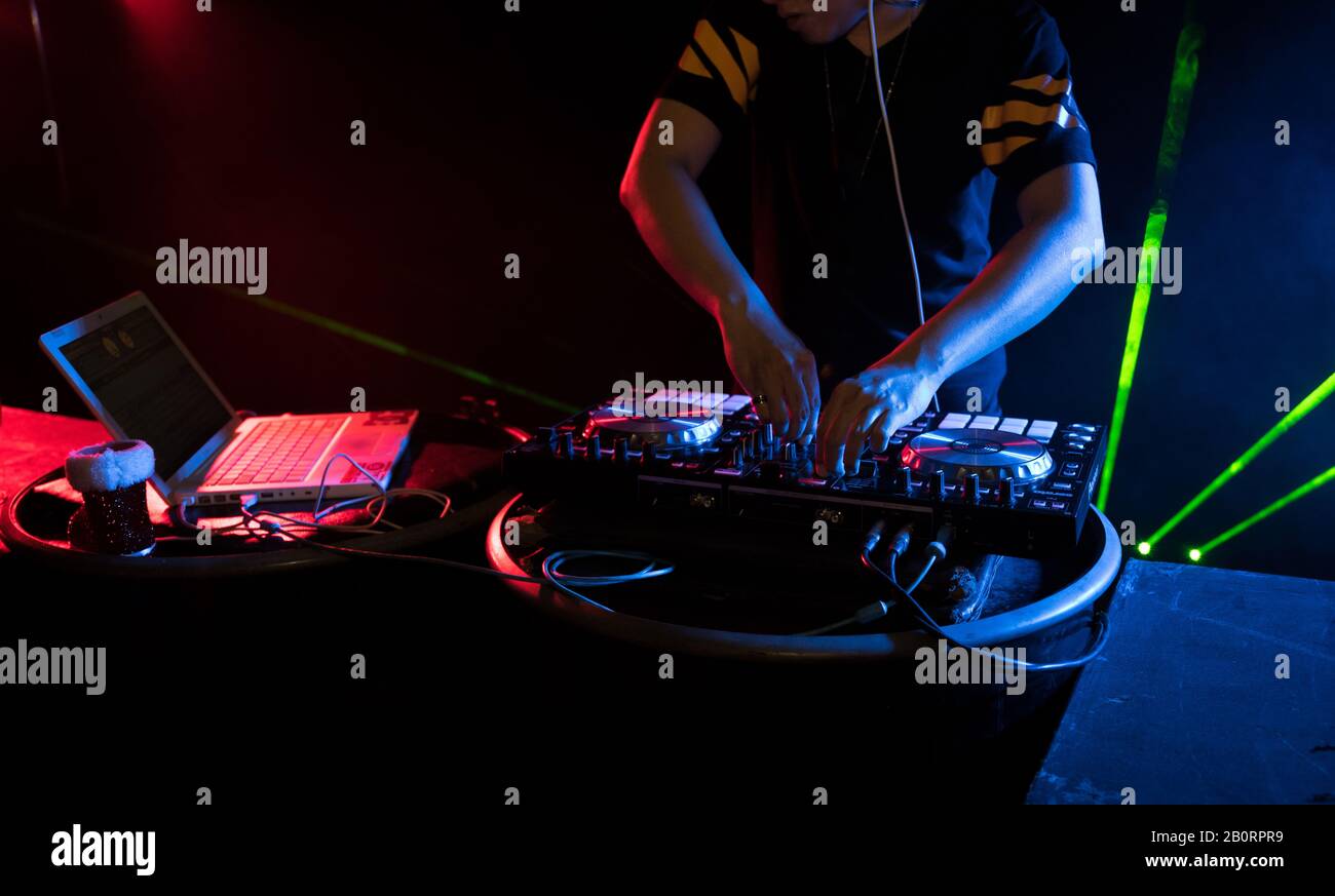 DJ playing turntable music on night club party Stock Photo - Alamy
