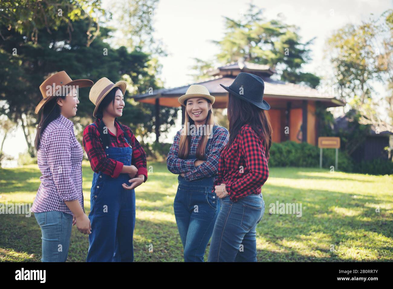 Four young woman in the park and talking about something.Friends ...