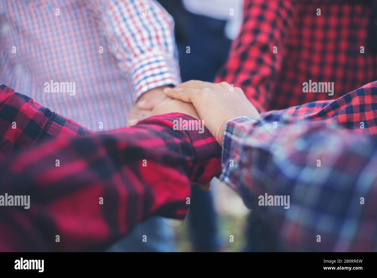 Close up top view of young business people putting their hands together ...