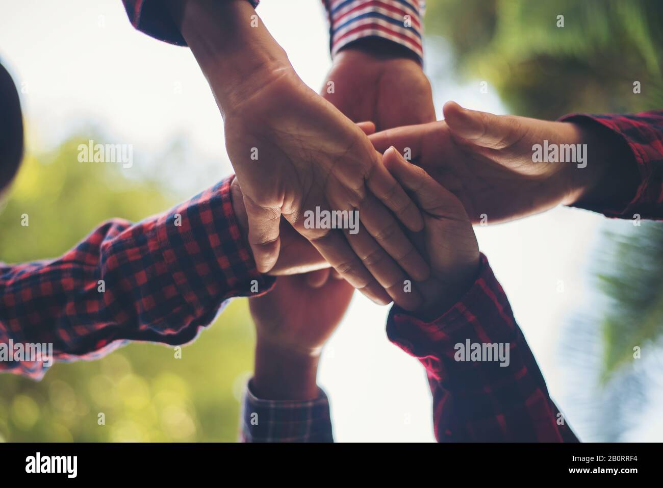 Close up top view of young business people putting their hands together. Unity and teamwork ...