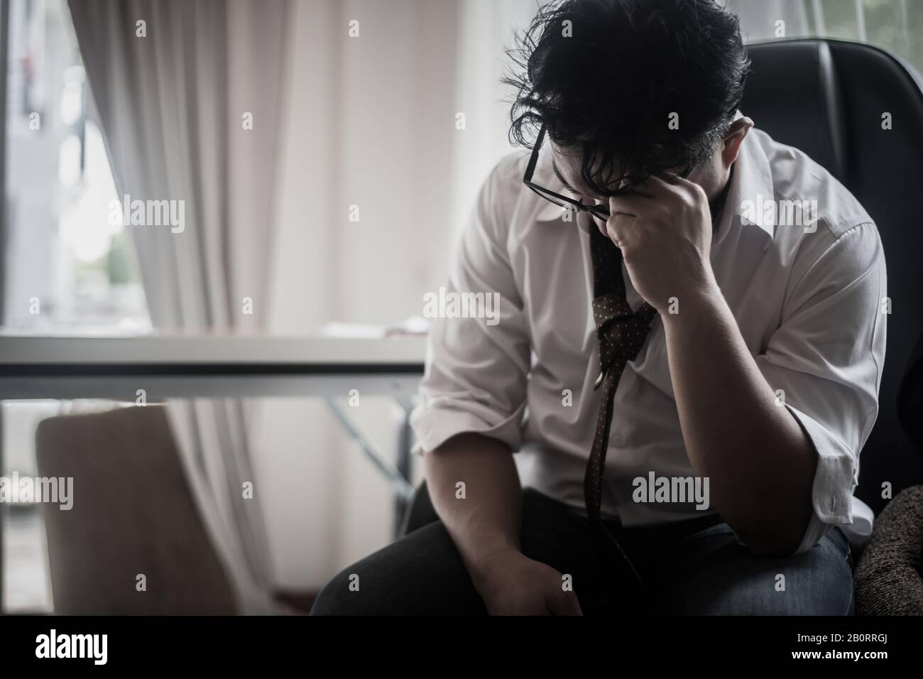 Worried business man at workplace in office after tired from hard work ...
