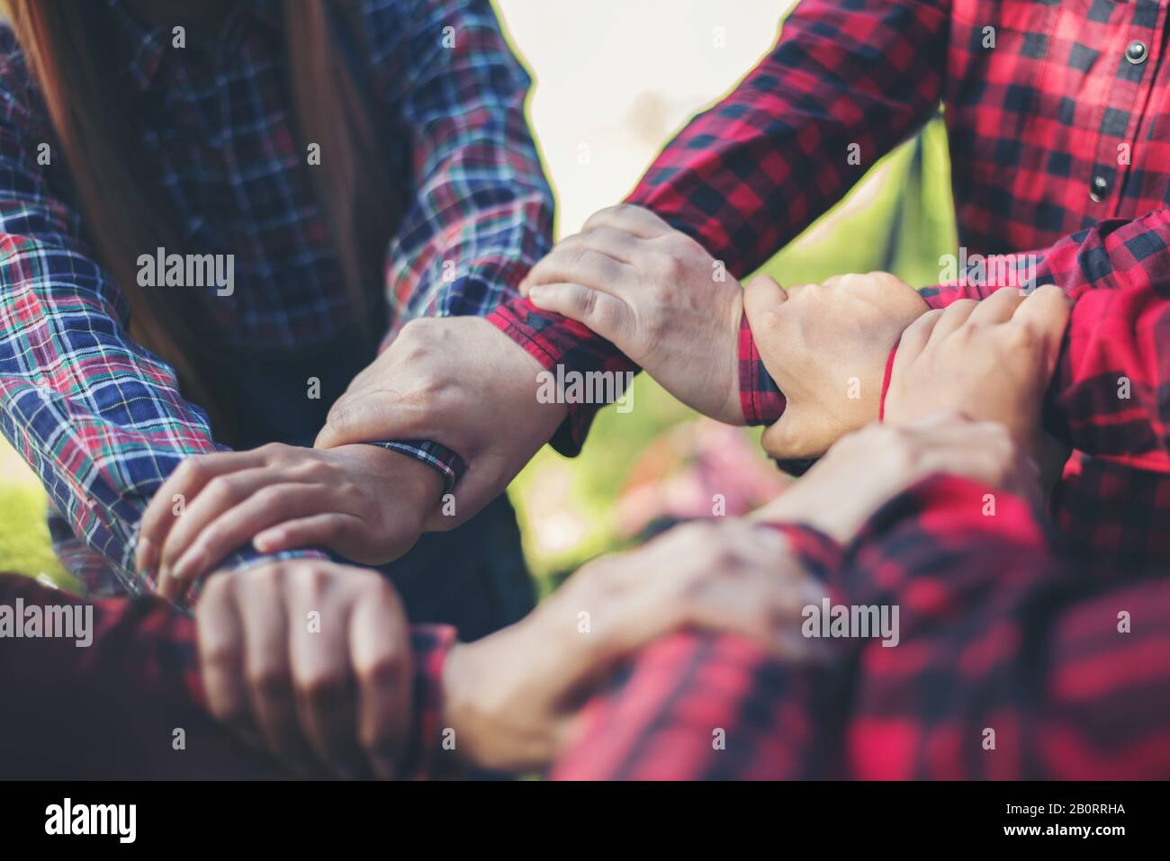 Close up top view of young business people putting their hands together ...