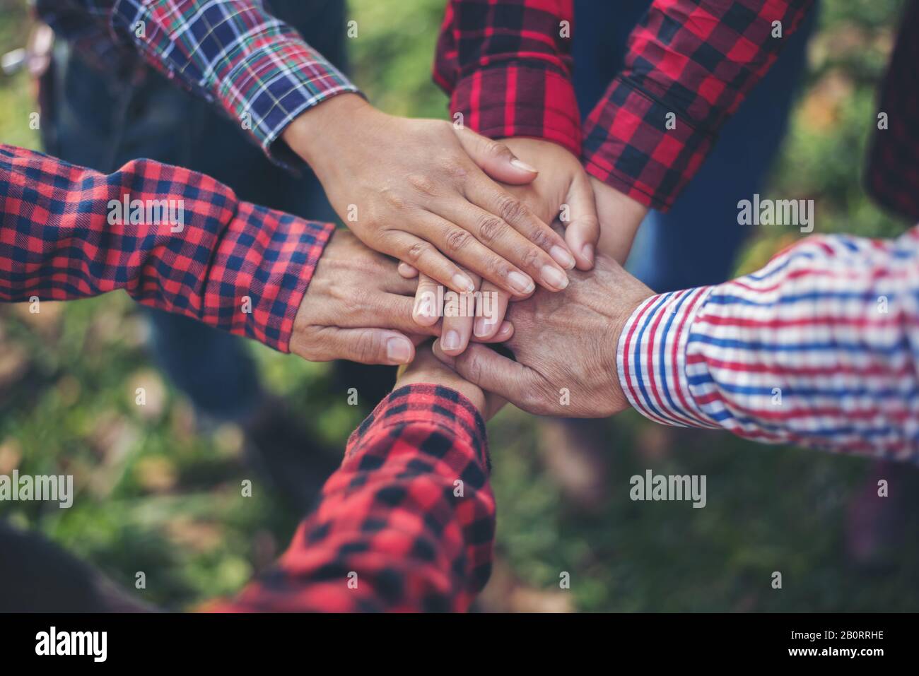 Close up top view of young business people putting their hands together ...