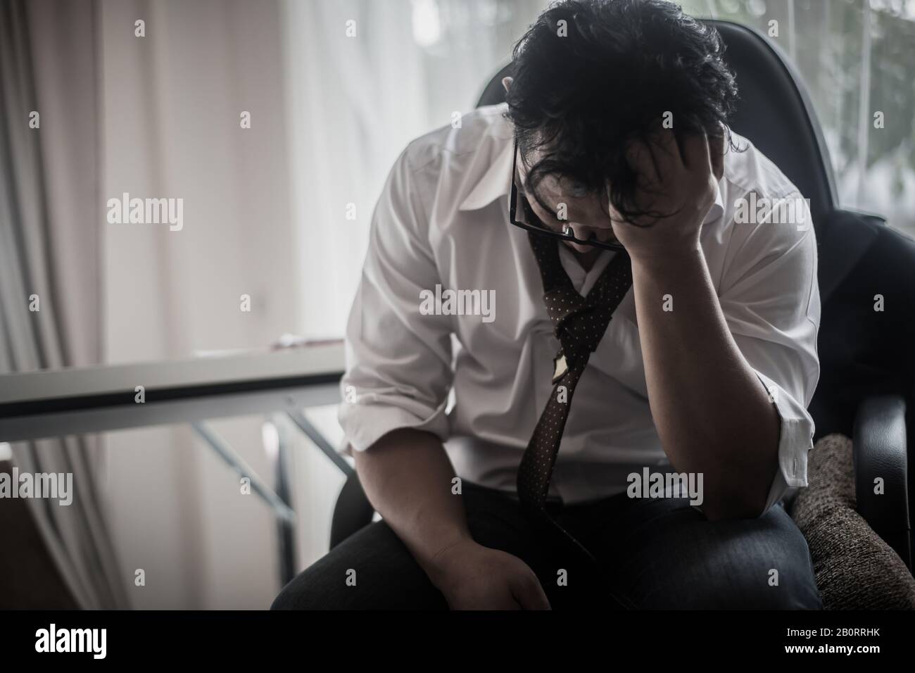 Worried business man at workplace in office after tired from hard work ...