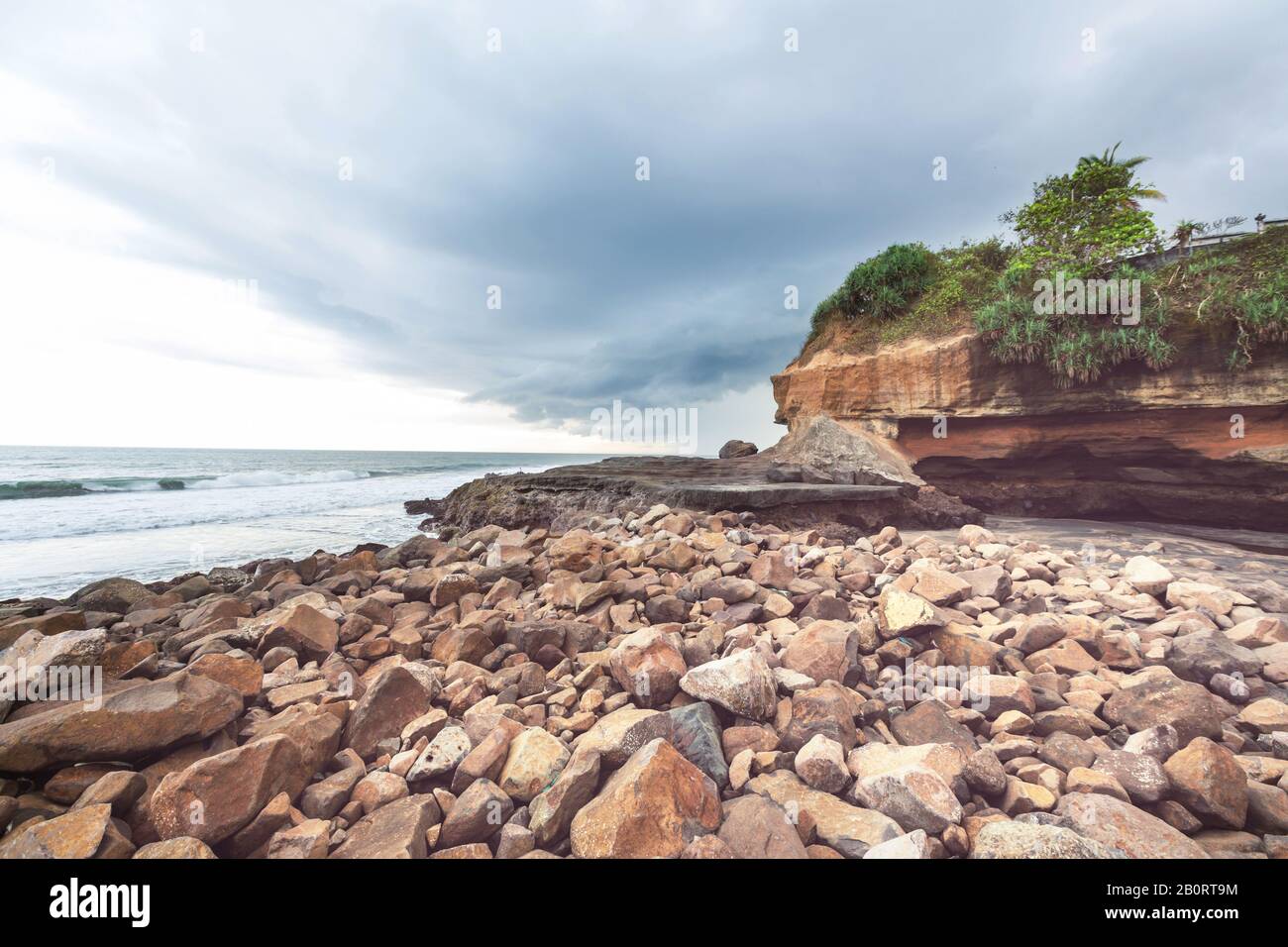 Volcanic beach with rocky mountains in Bali, Indonesia Stock Photo - Alamy