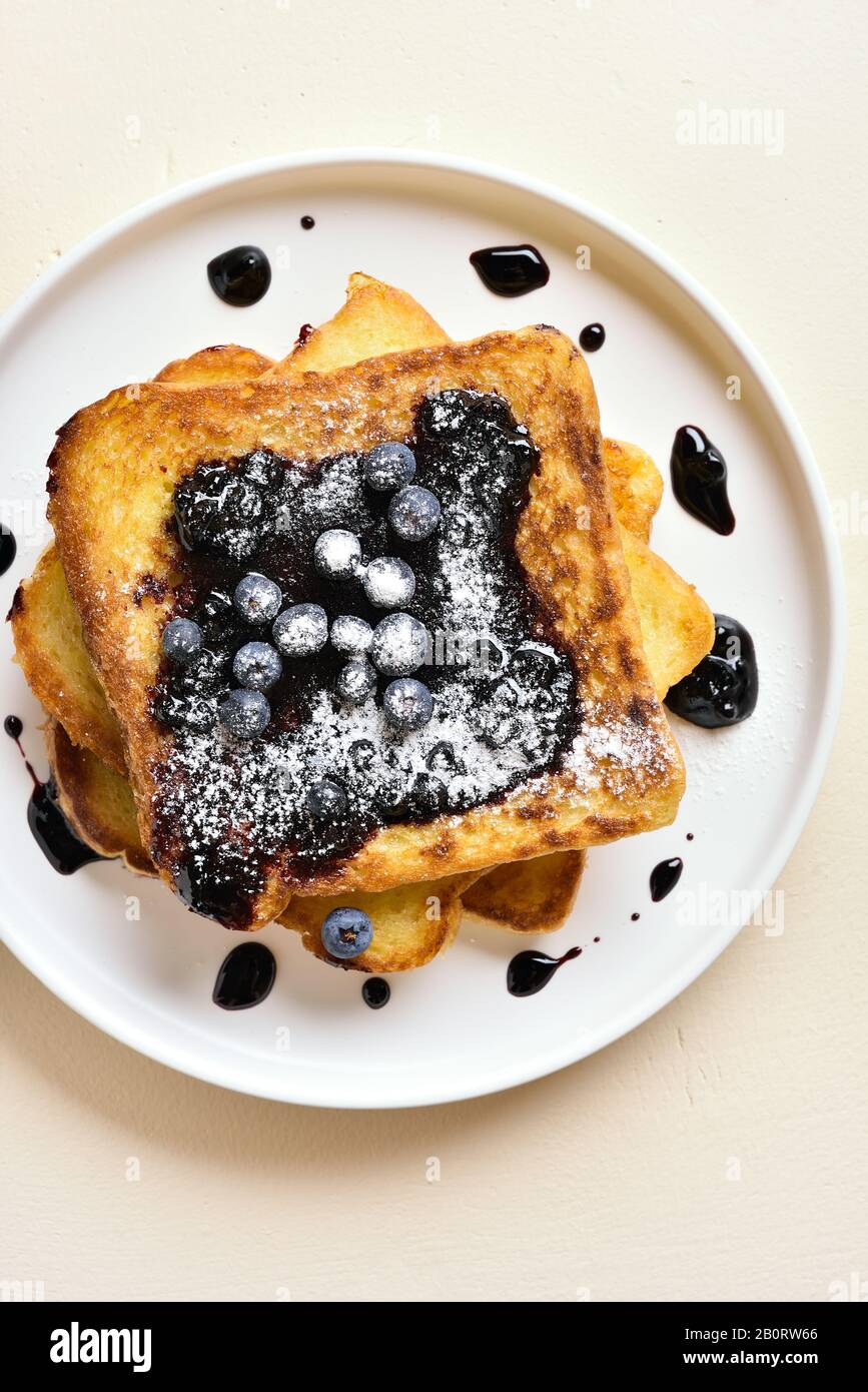 Close up of french toasts with blueberry sauce on light stone ...