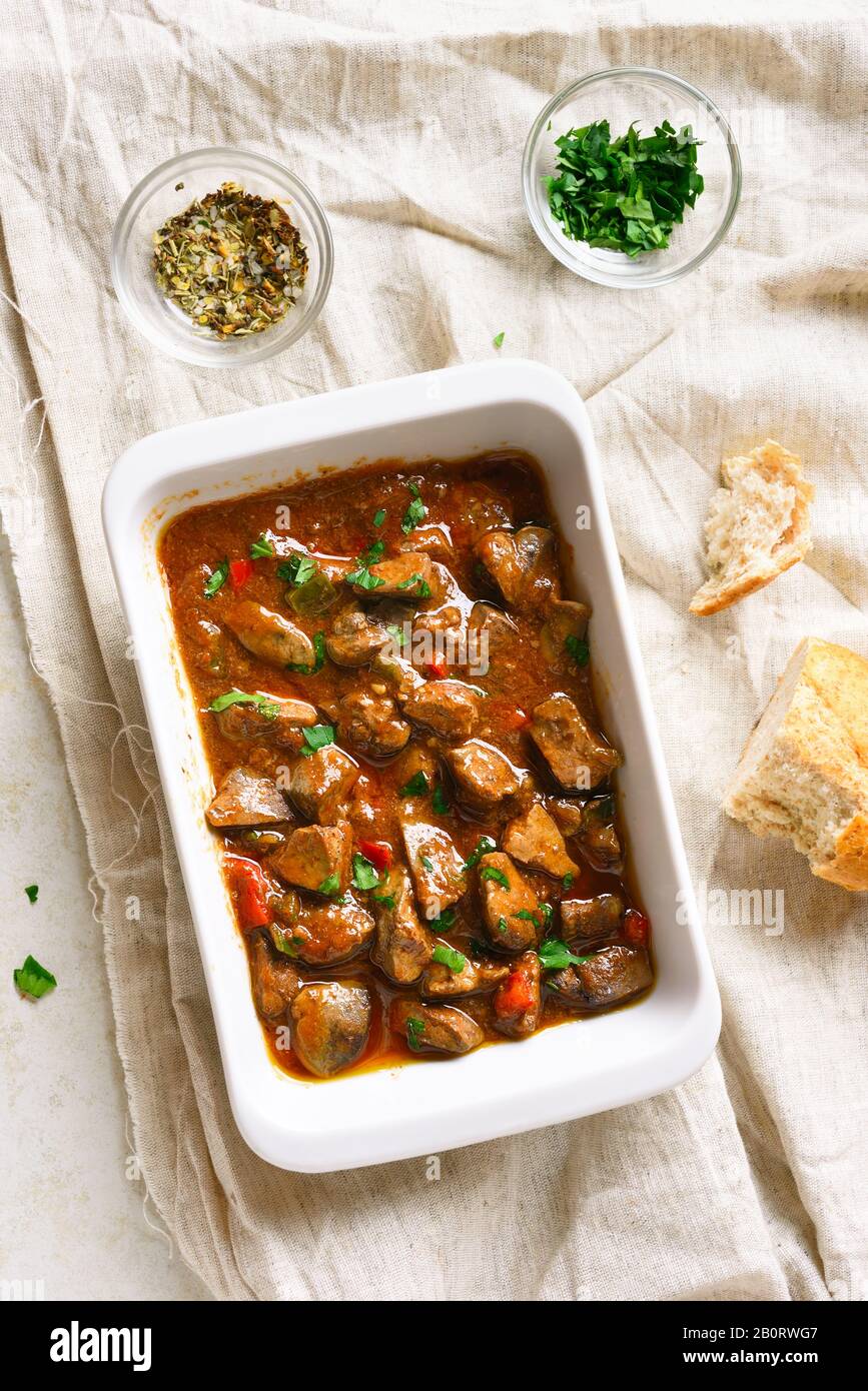 Peri-peri chicken livers in baking dish over light background. Top view ...