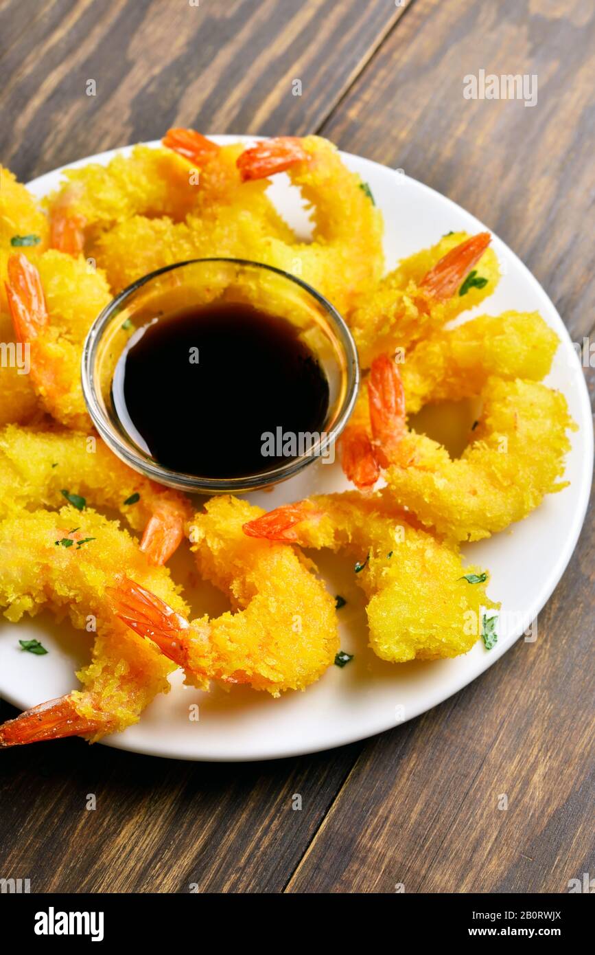 Deep fried breaded shrimp with sauce on plate on wooden table Stock ...