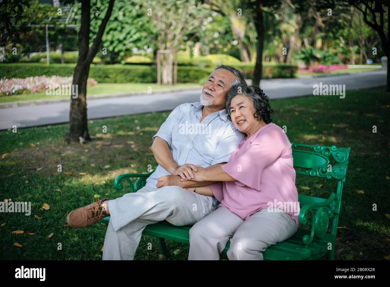 healthy senior couple relaxing seats on the bench in the park Stock ...