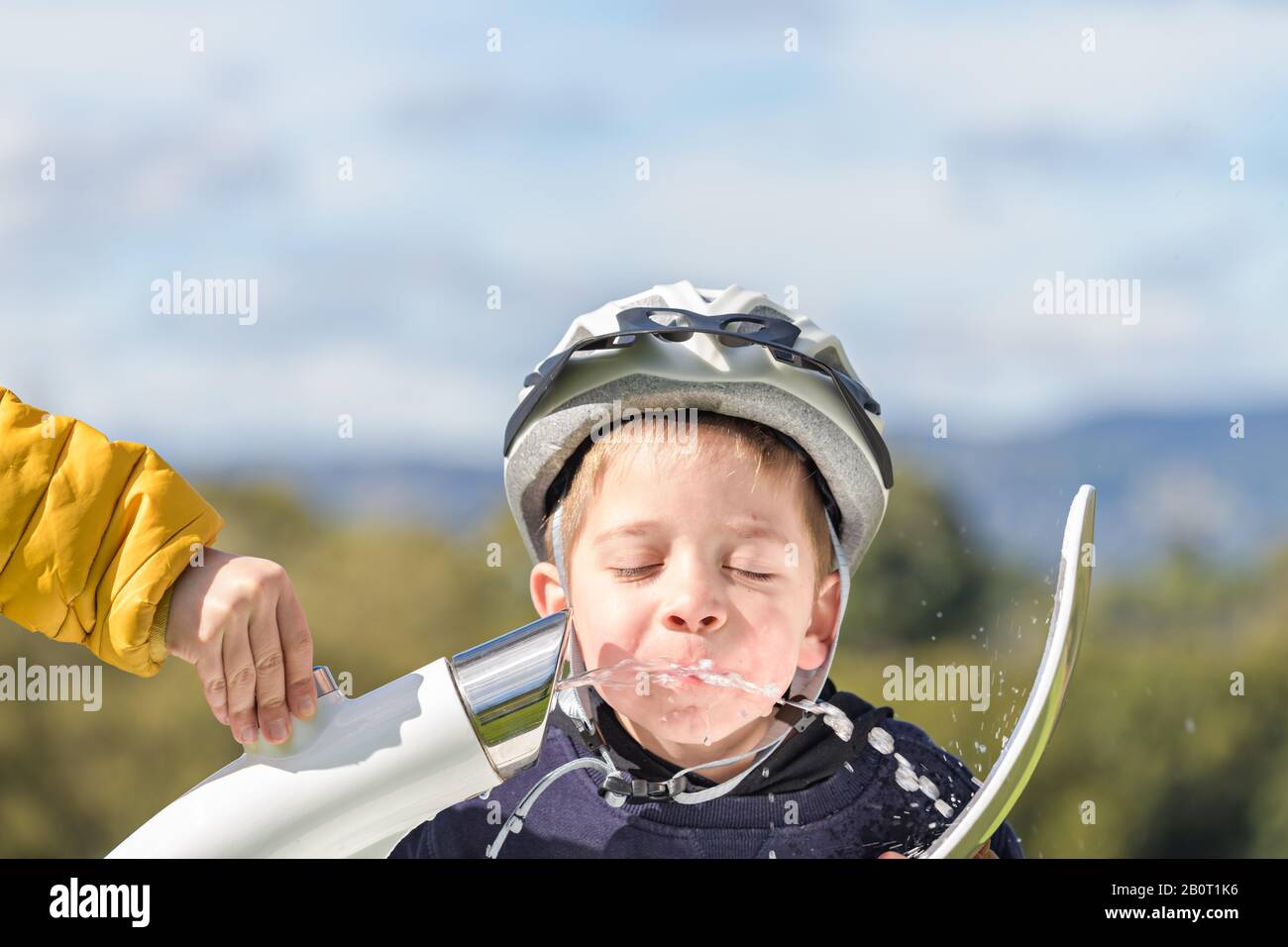 Young boy drinking water from public street bubbler in Adelaide city ...