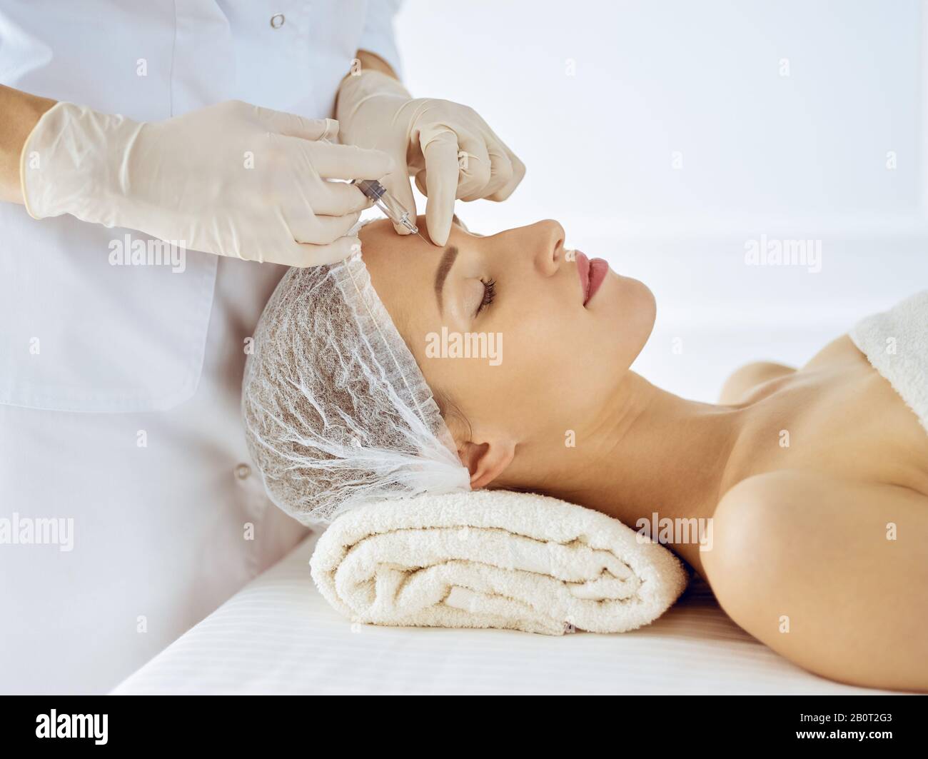 Beautiful woman receiving beauty injections with closed eyes ...